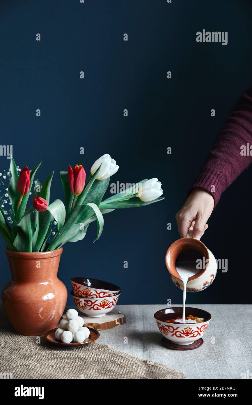 Kazakh woman pouring milk in Kazakh tea bowl kese with ornament near ...