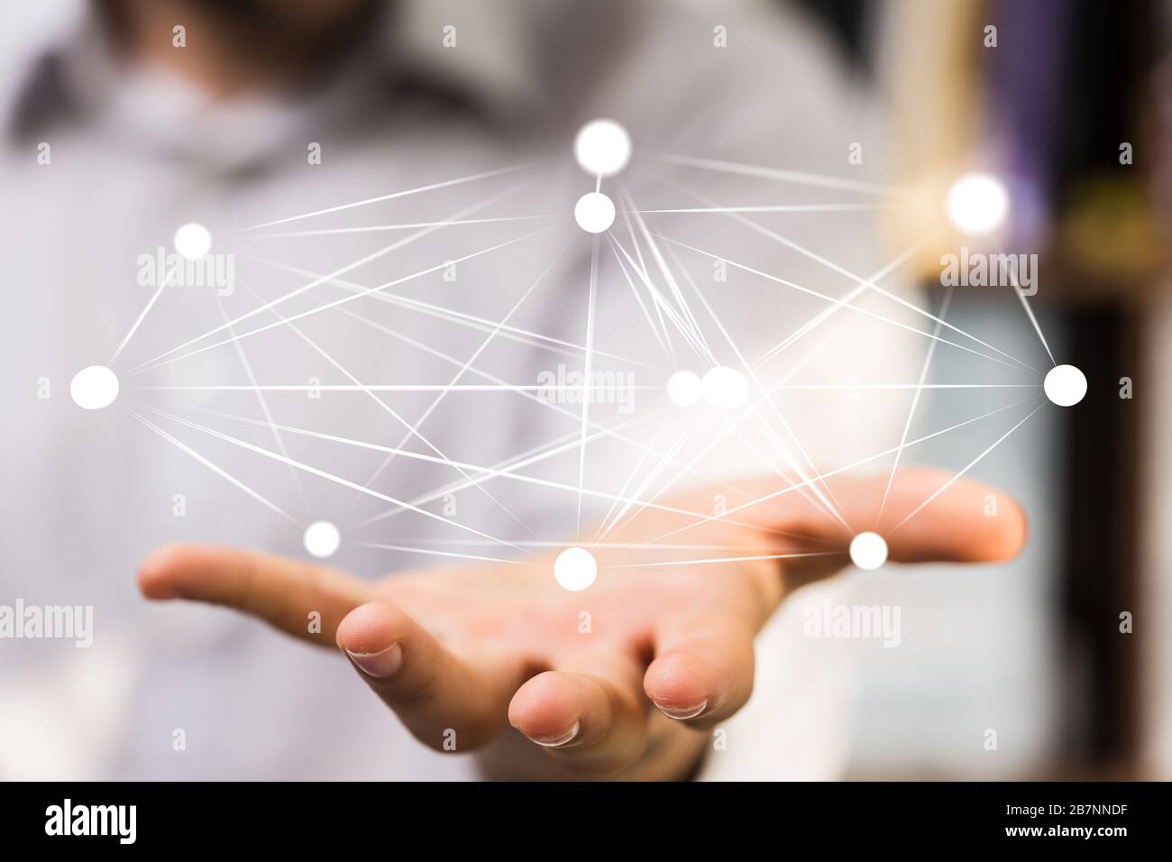 Male hand holding an interface with small circles connected depicting ...