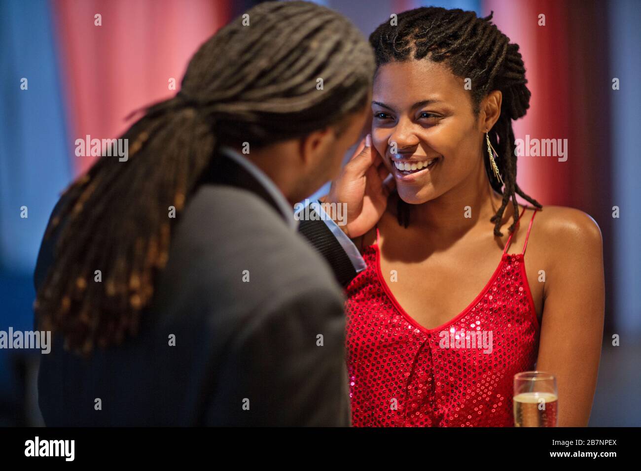 Young man gently touching the cheek of the smiling young woman he is ...