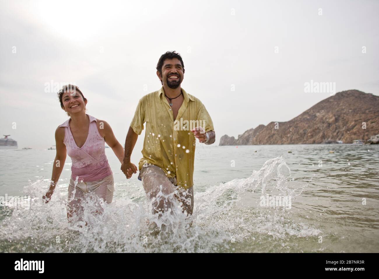 Couple running in the ocean Stock Photo - Alamy