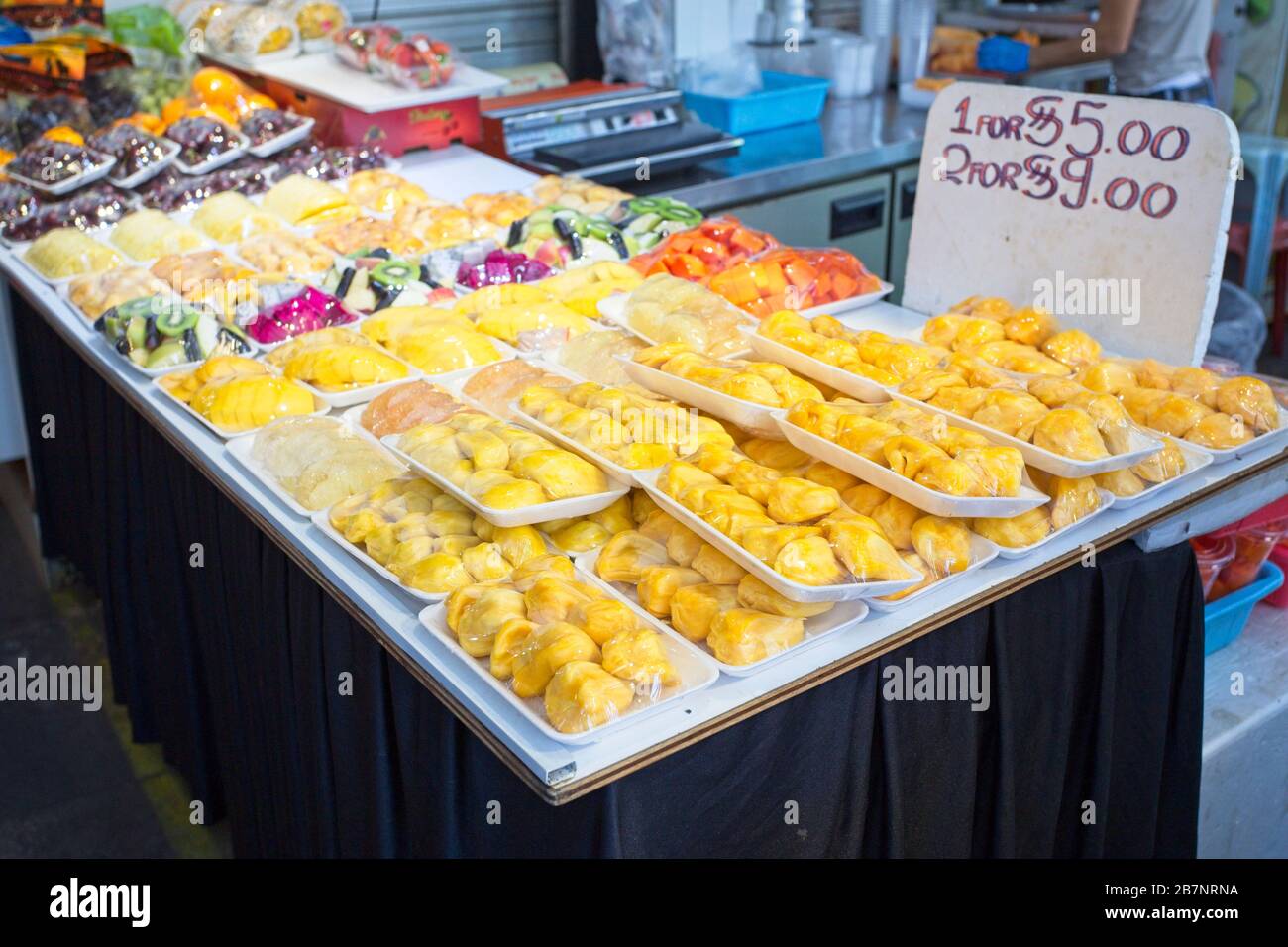 Fresh fruit packaged in plastic and sold on a food stall in Bugis ...
