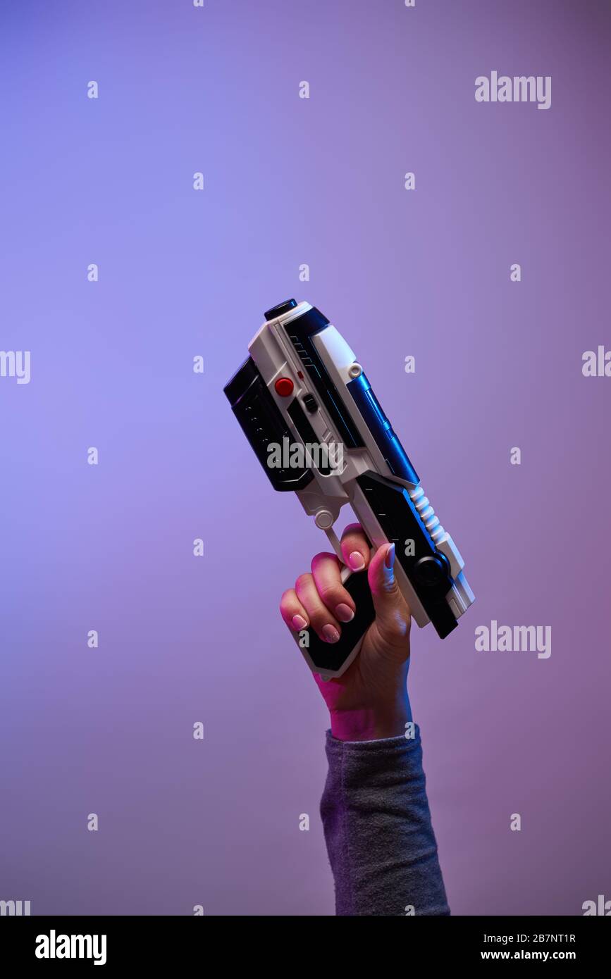 Female hands with blaster for games on purple background. Concept of ...