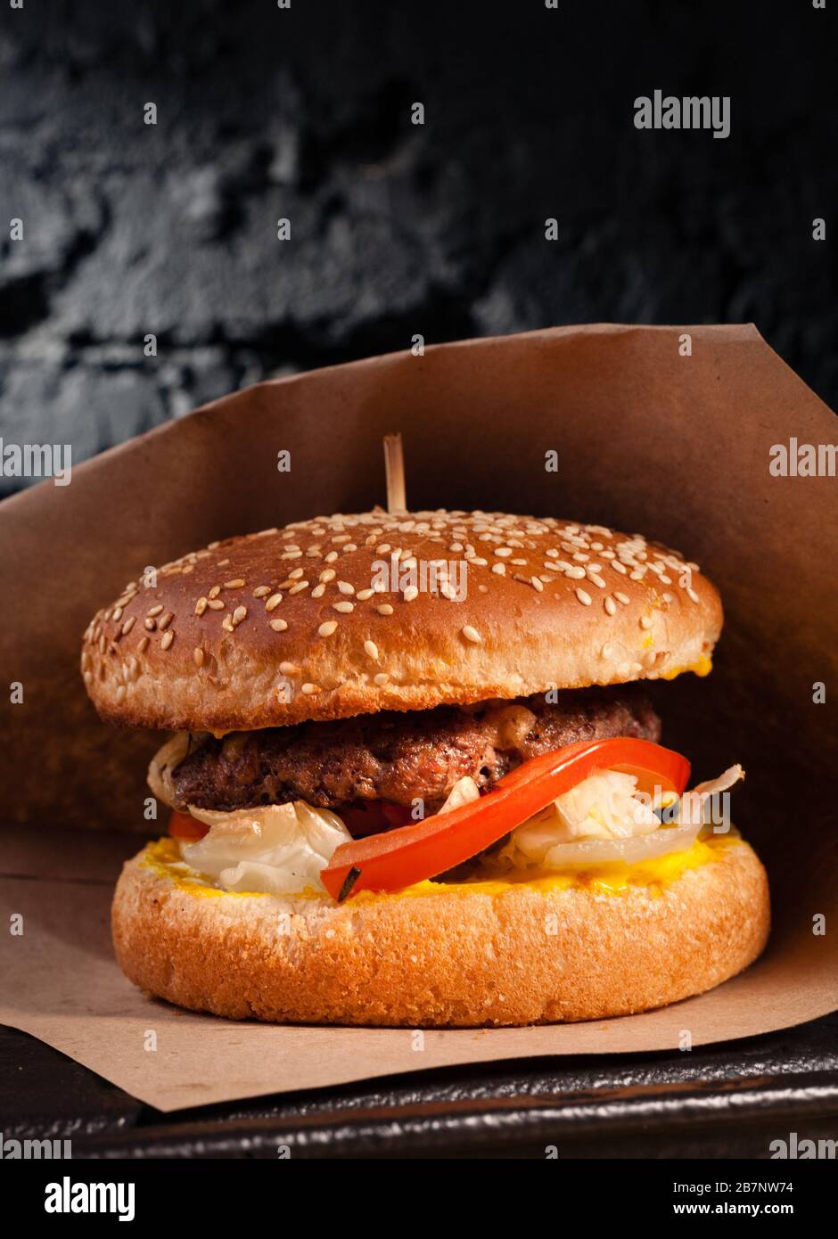 Close-up of meat burger in paper packaging. Against the background of a ...