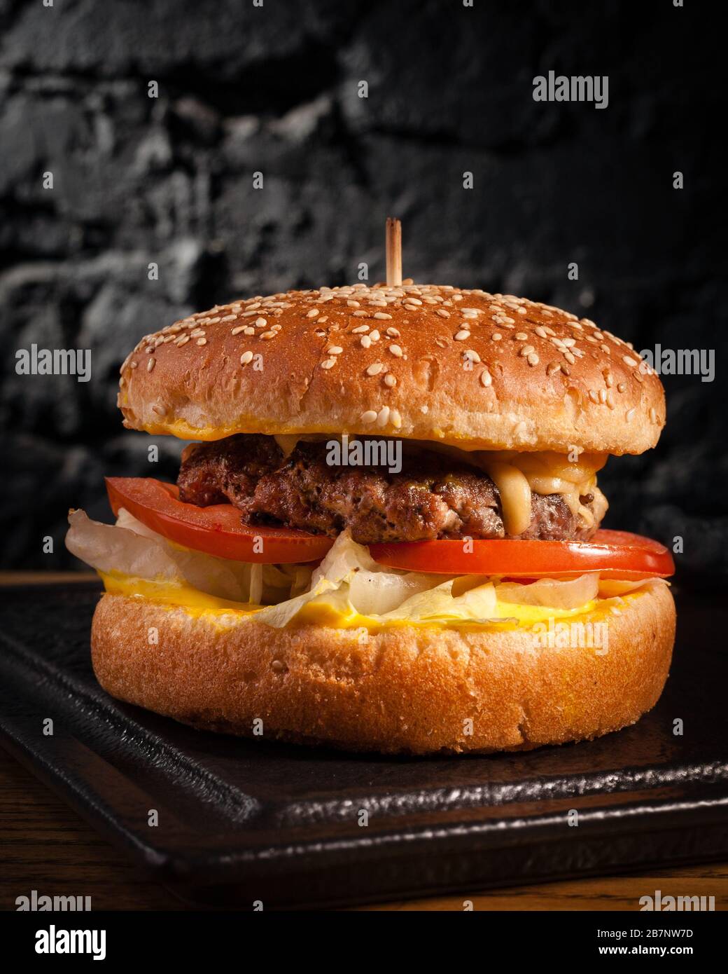 Meat burger on black wall background, side view Stock Photo - Alamy
