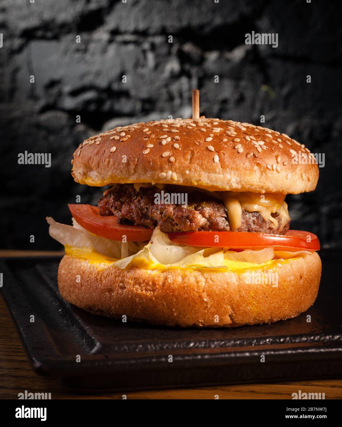 Meat burger on black wall background, side view Stock Photo - Alamy