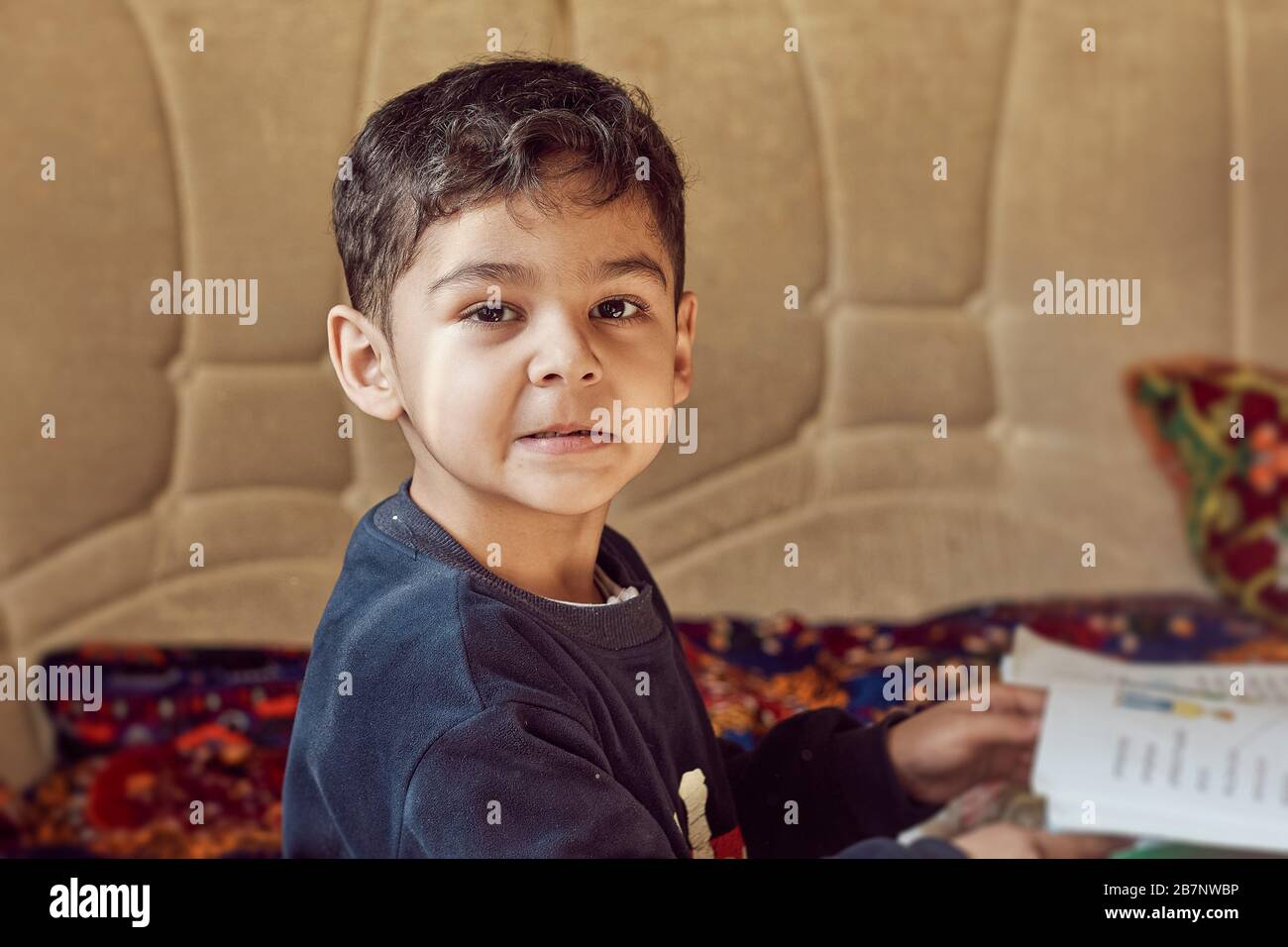A little schoolboy doing homework. Reading book. Authentic view of a ...