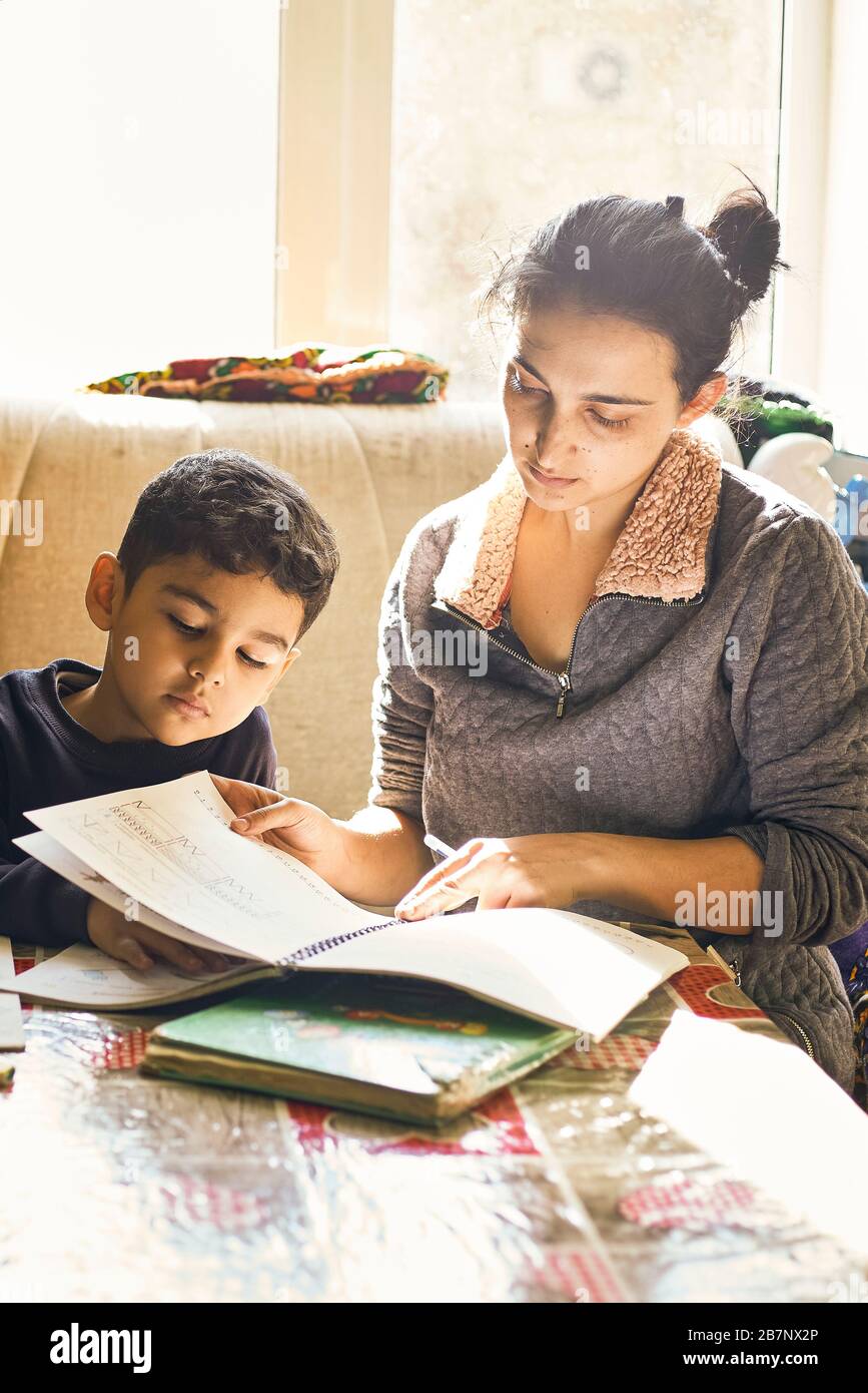 Parenting help with homework. Authentic photo of young mother helping ...
