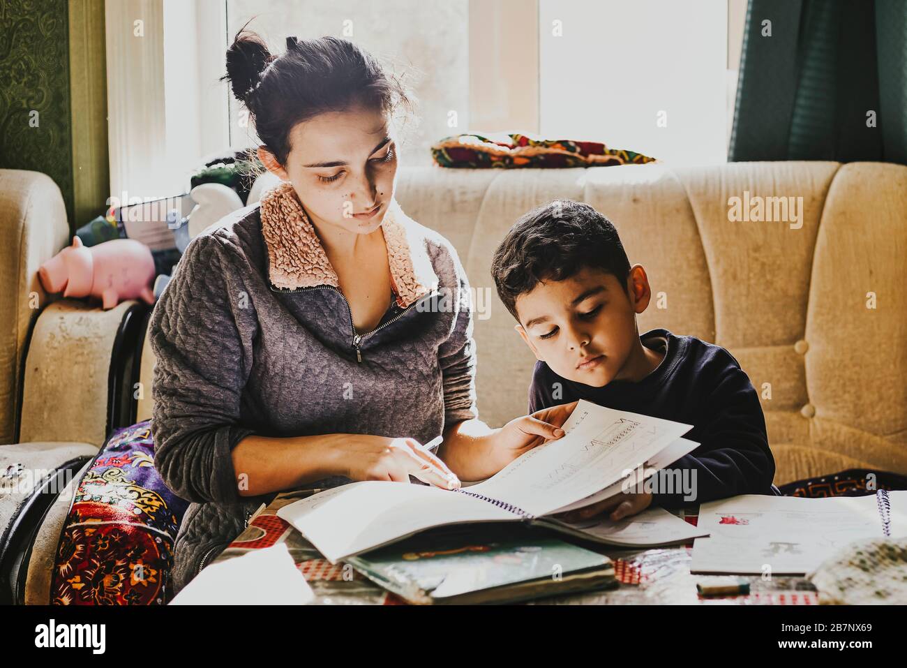 Parenting help with homework. Authentic photo of young mother helping ...