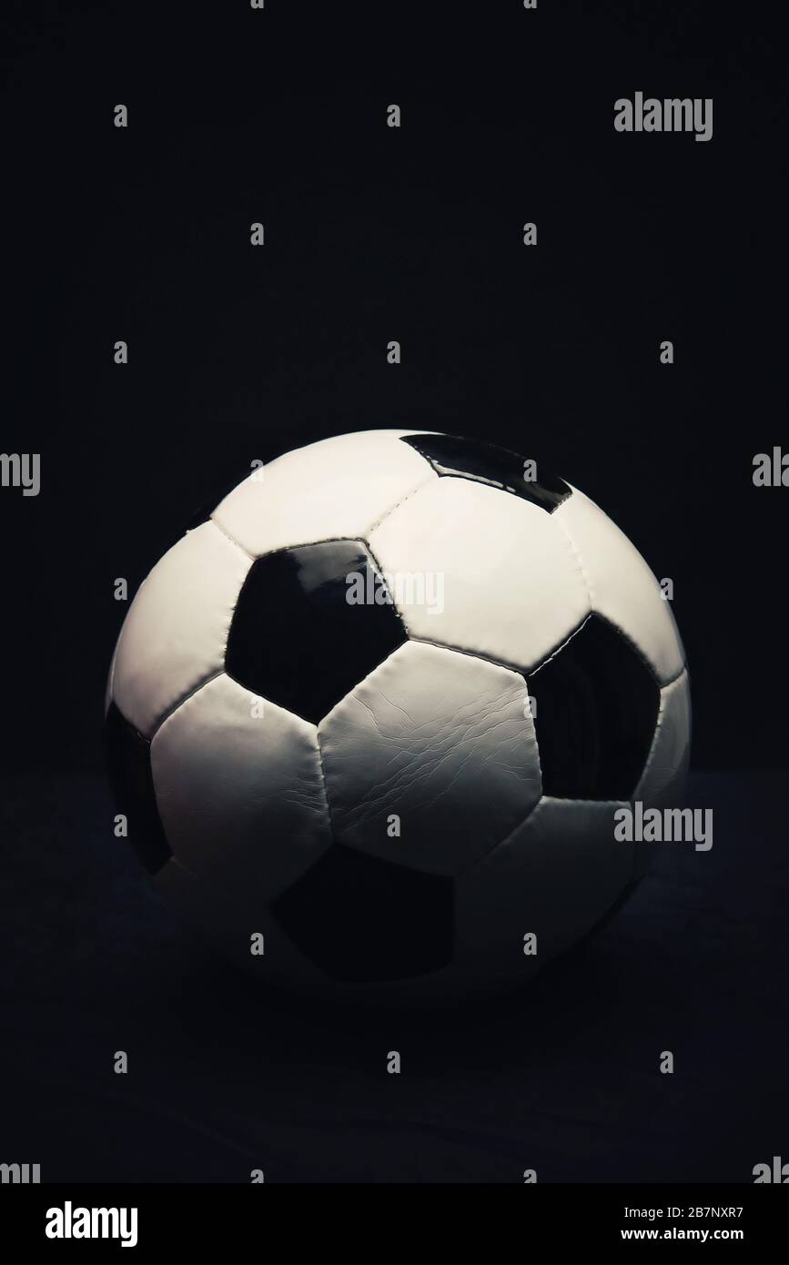 Vertical photo of classic football ball isolated on a black background ...