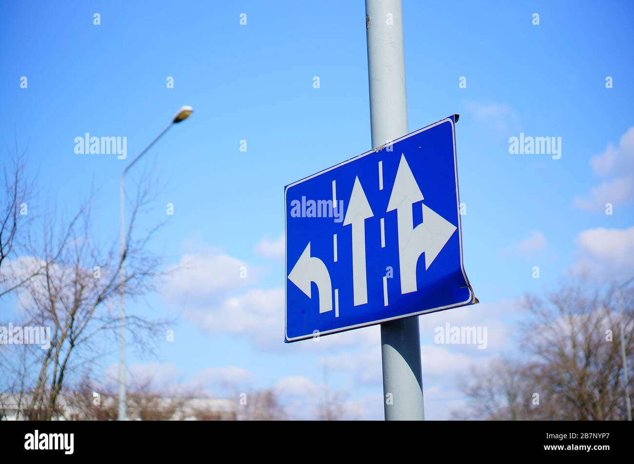 Blue traffic sign with arrows on a pole Stock Photo - Alamy