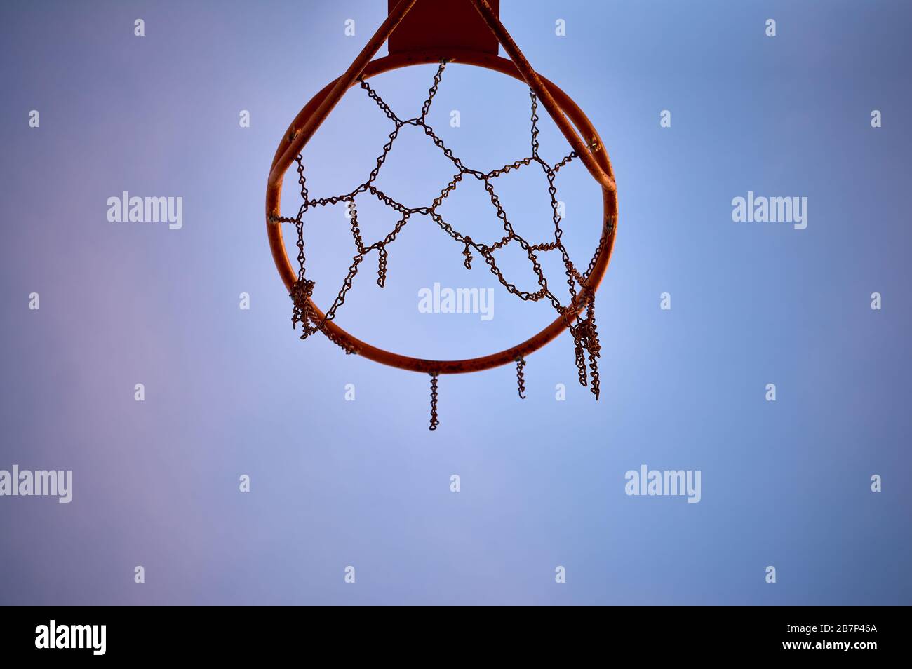 isolated detail of the hoop of an orange basketball net with a chain by ...