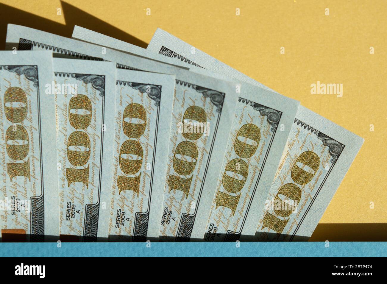 Six pieces of 100 dollar bills on the yellow and blue background ...