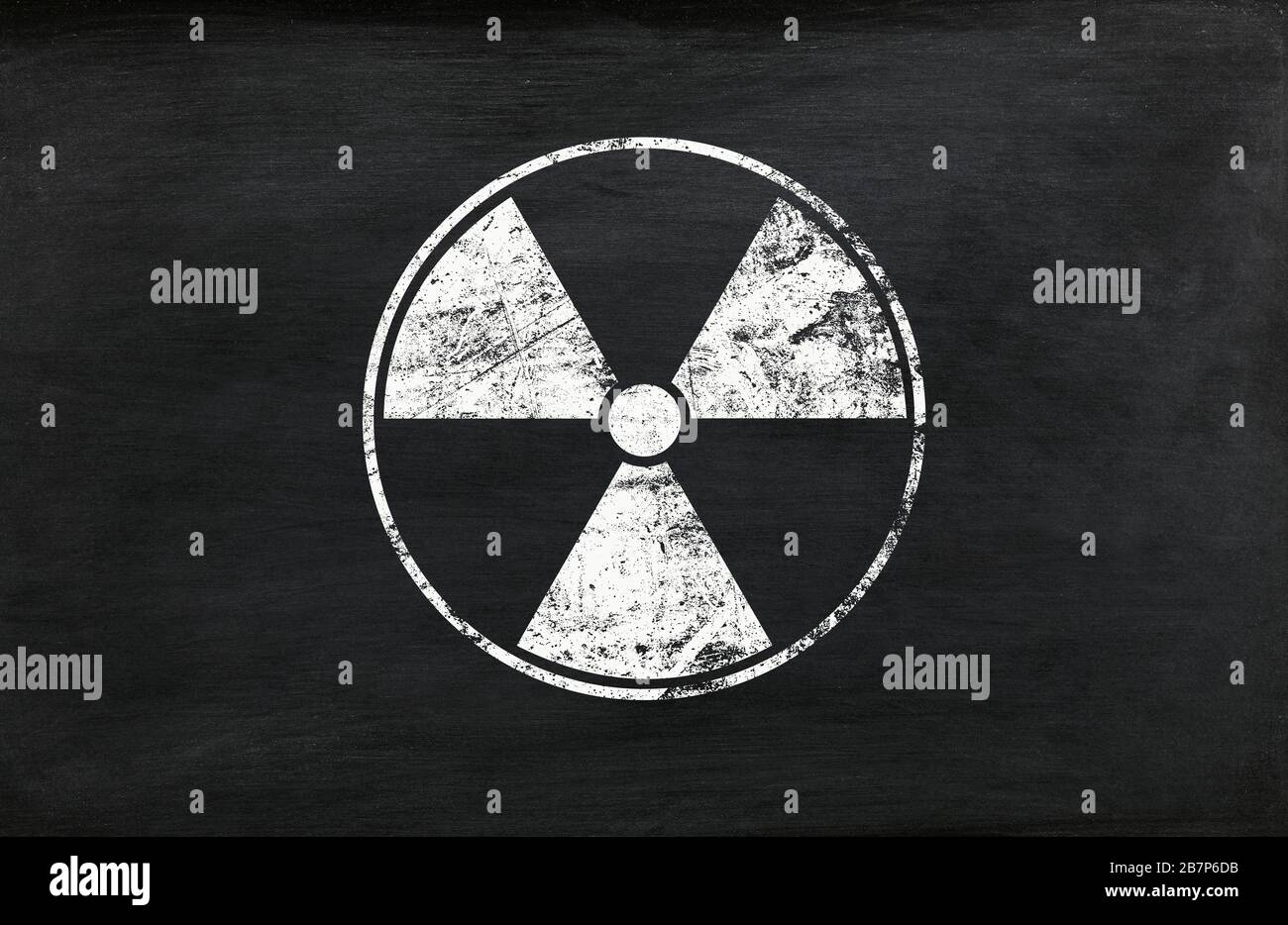 White chalk radioactive hazard warning sign over grunge black ...