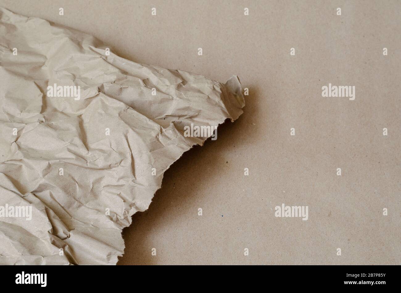 Used and new packaging paper. Crumpled piece of paper on a plain paper ...