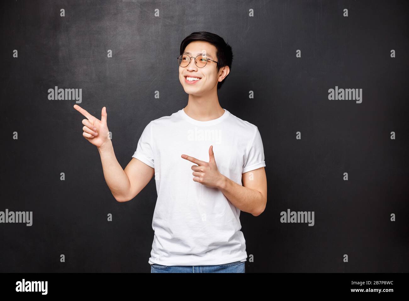 Handsome young healthy asian guy in white shirt contemplate something ...