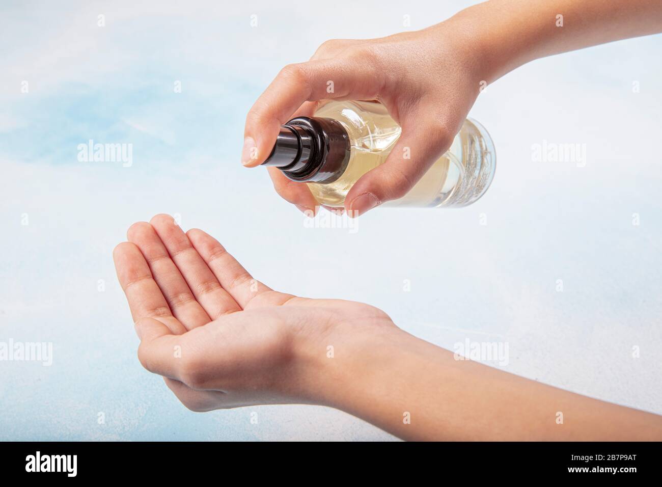 person pouring cologne on their hands for personal hand cleaning Stock ...