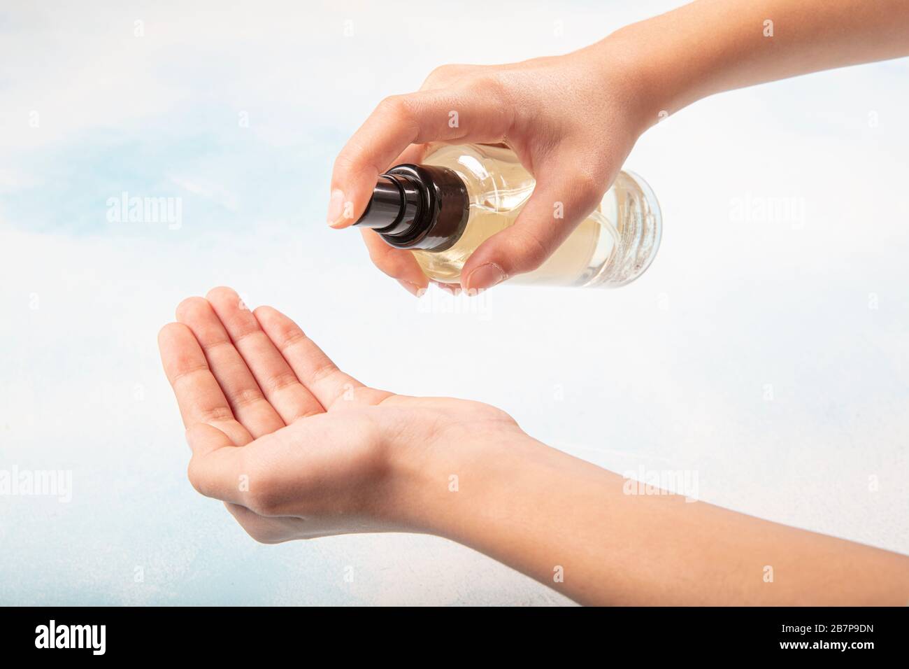person pouring cologne on their hands for personal hand cleaning Stock ...