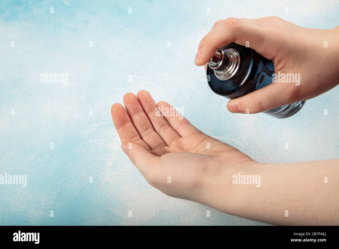 person pouring cologne on their hands for personal hand cleaning Stock ...