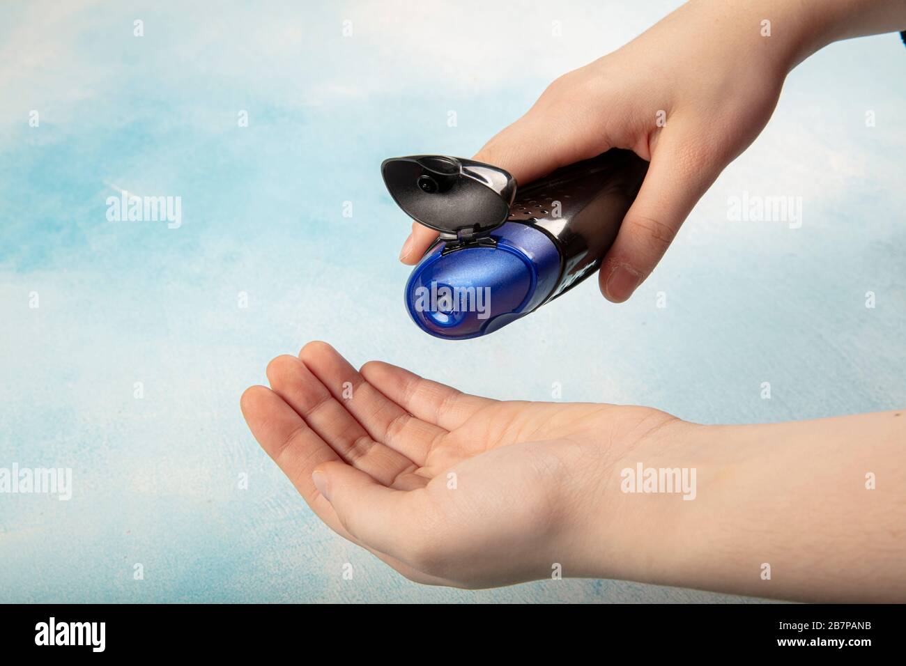 person pouring cologne on their hands for personal hand cleaning Stock ...