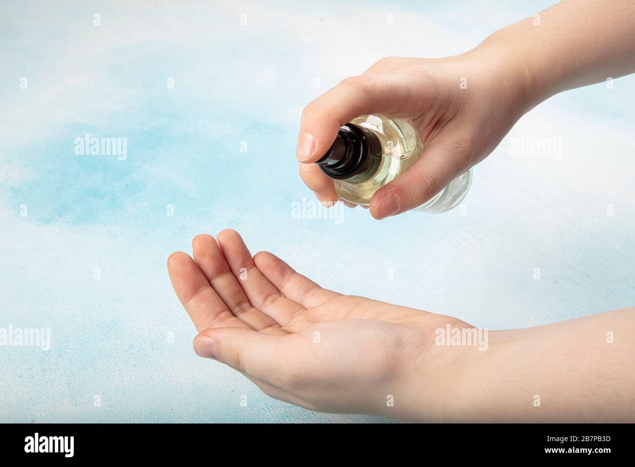 person pouring cologne on their hands for personal hand cleaning Stock ...
