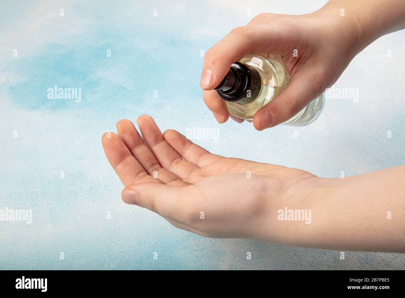 person pouring cologne on their hands for personal hand cleaning Stock ...
