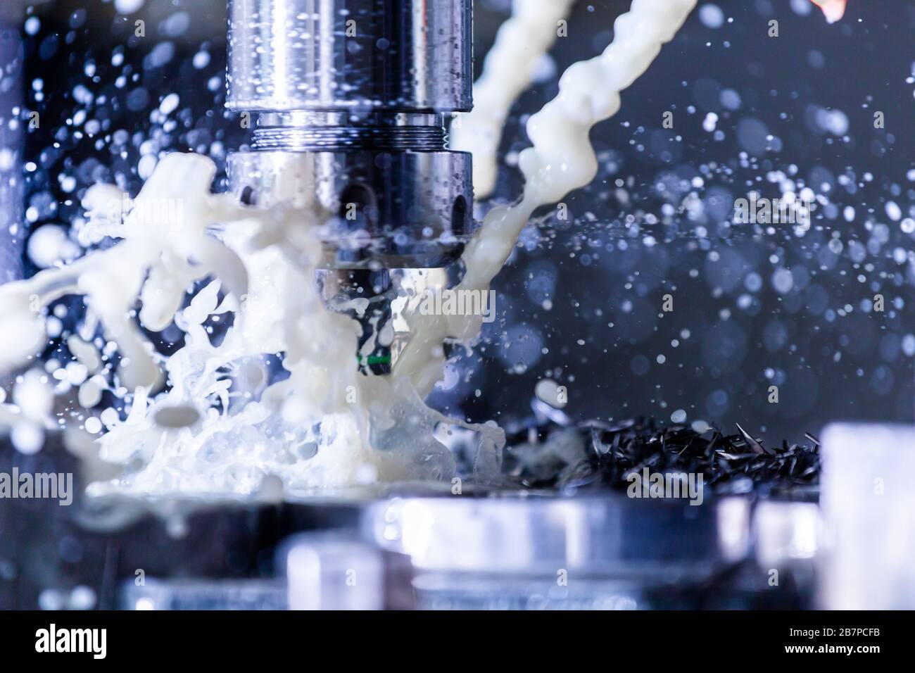 Close-up view of vertical cnc steel milling process with external water ...