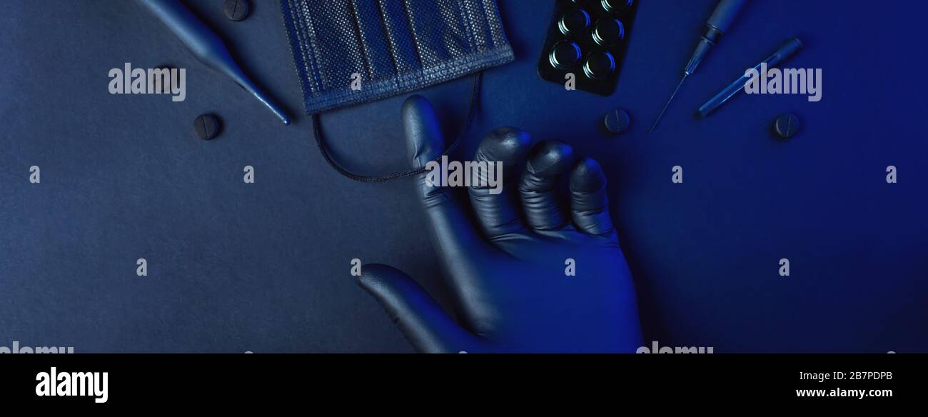 A switch on the virus. Hand in glove, mask, tablets, syringe, vials lie ...
