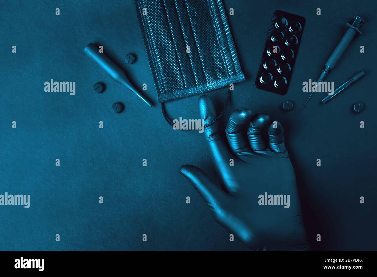 A switch on the virus. Hand in glove, mask, tablets, syringe, vials lie ...