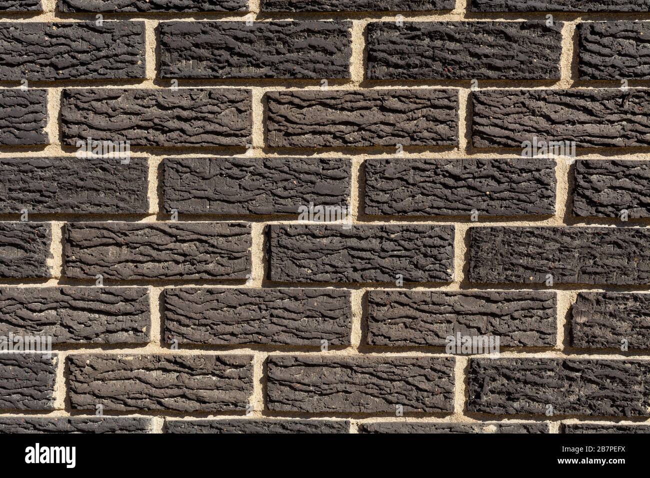 Decorative textured black brick wall Stock Photo - Alamy