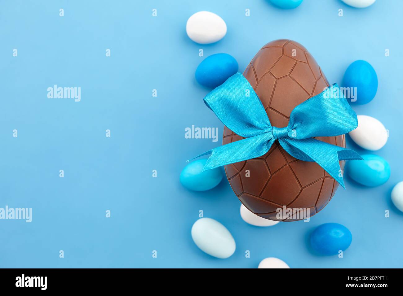 Chocolate Easter egg with blue and white candies Stock Photo - Alamy