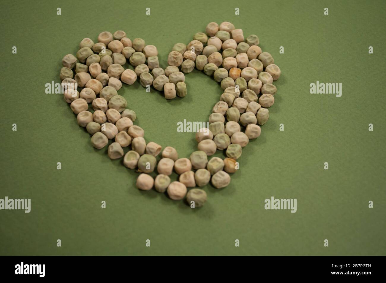 Heart shape with dried pea seeds on green background Stock Photo - Alamy