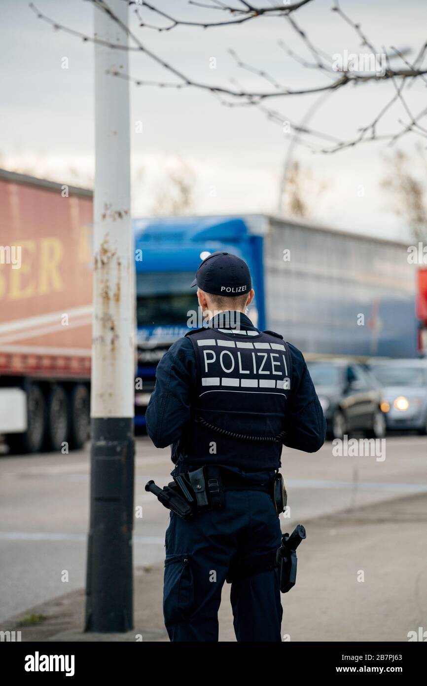 Rear view of unrecognizable German Polizei Police officer inspecting ...