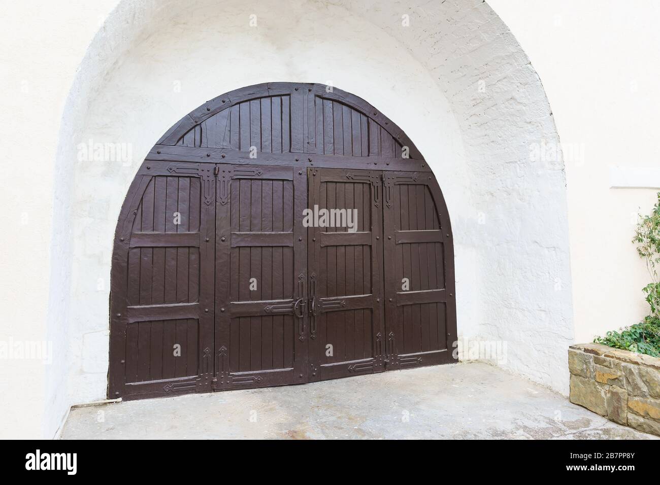 A semi-circular gate in the old wine cellars. The wooden door is ...