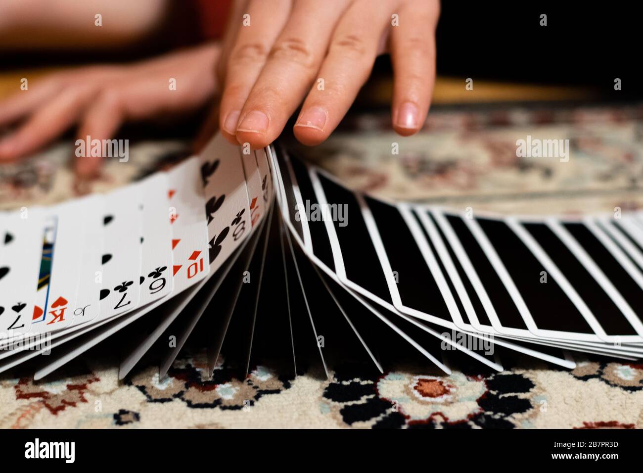 A person doing a ribbon spread with his playing cards Stock Photo - Alamy