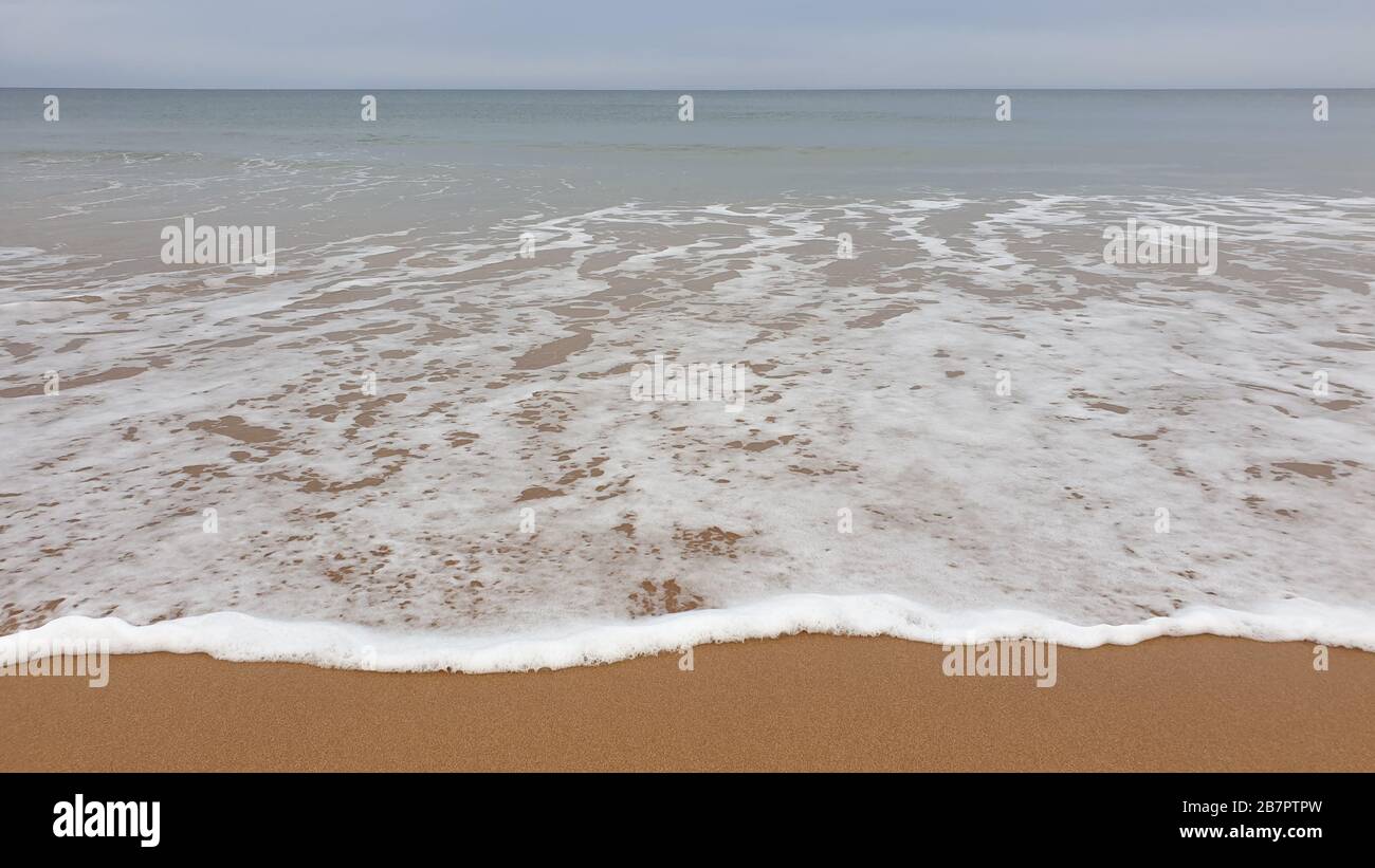Waves breaking on beach Stock Photo - Alamy