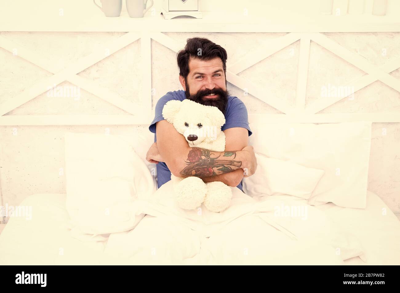 Man hug soft toy relaxing in bed. Make surprise concept. Gift for ...