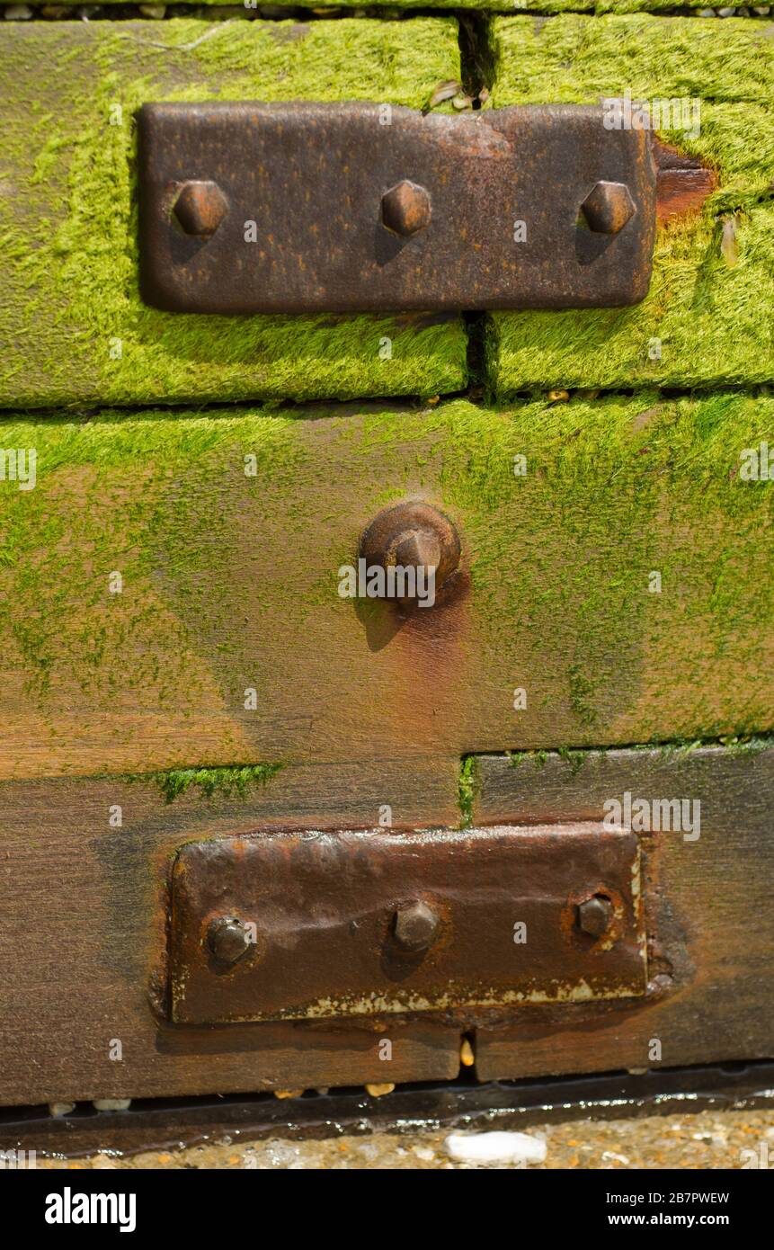 A weather beaten wooden groyne on an Isle of Wight shingle beach worn ...