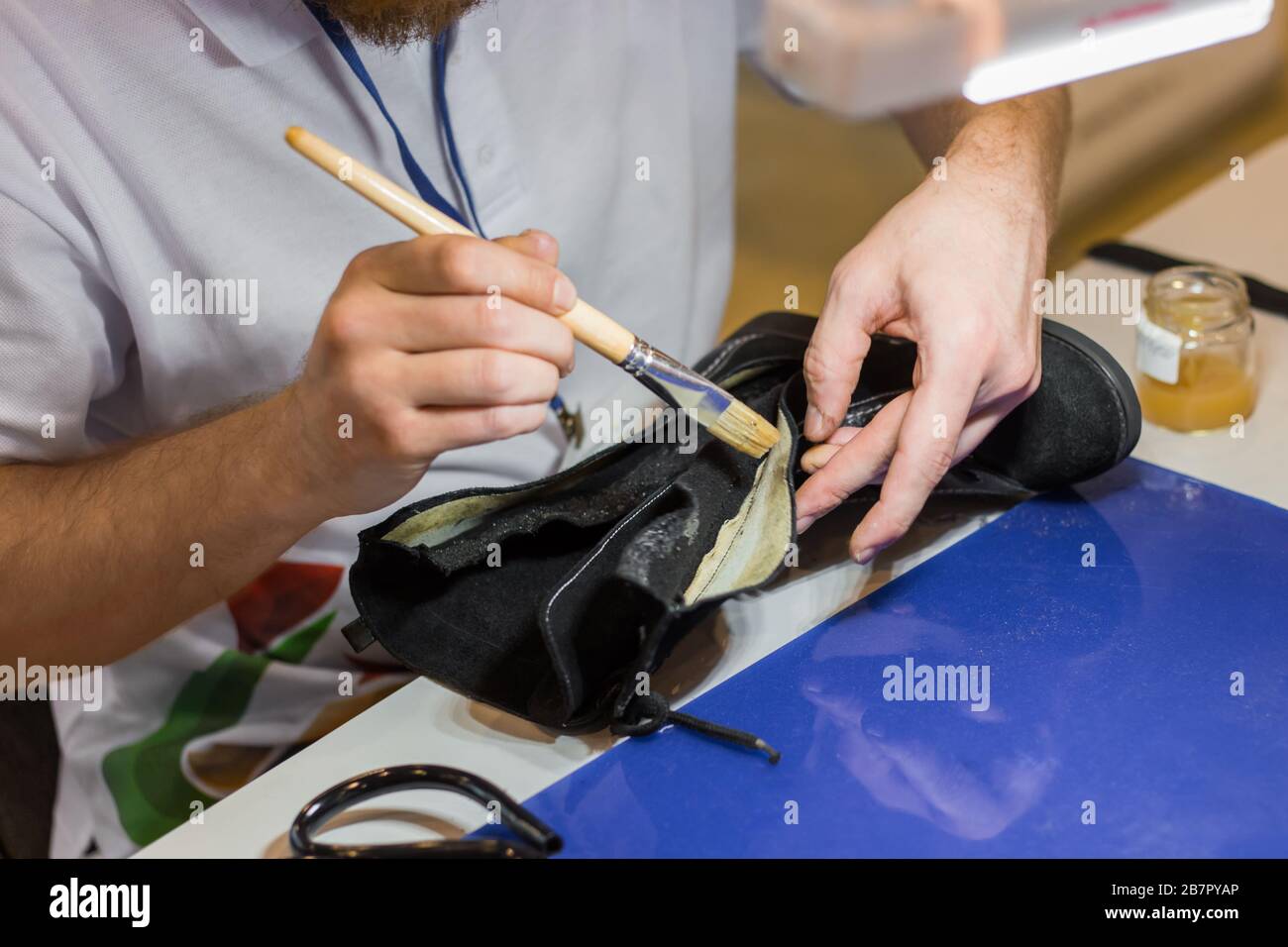 Shoemaker repairing black female boot Stock Photo - Alamy