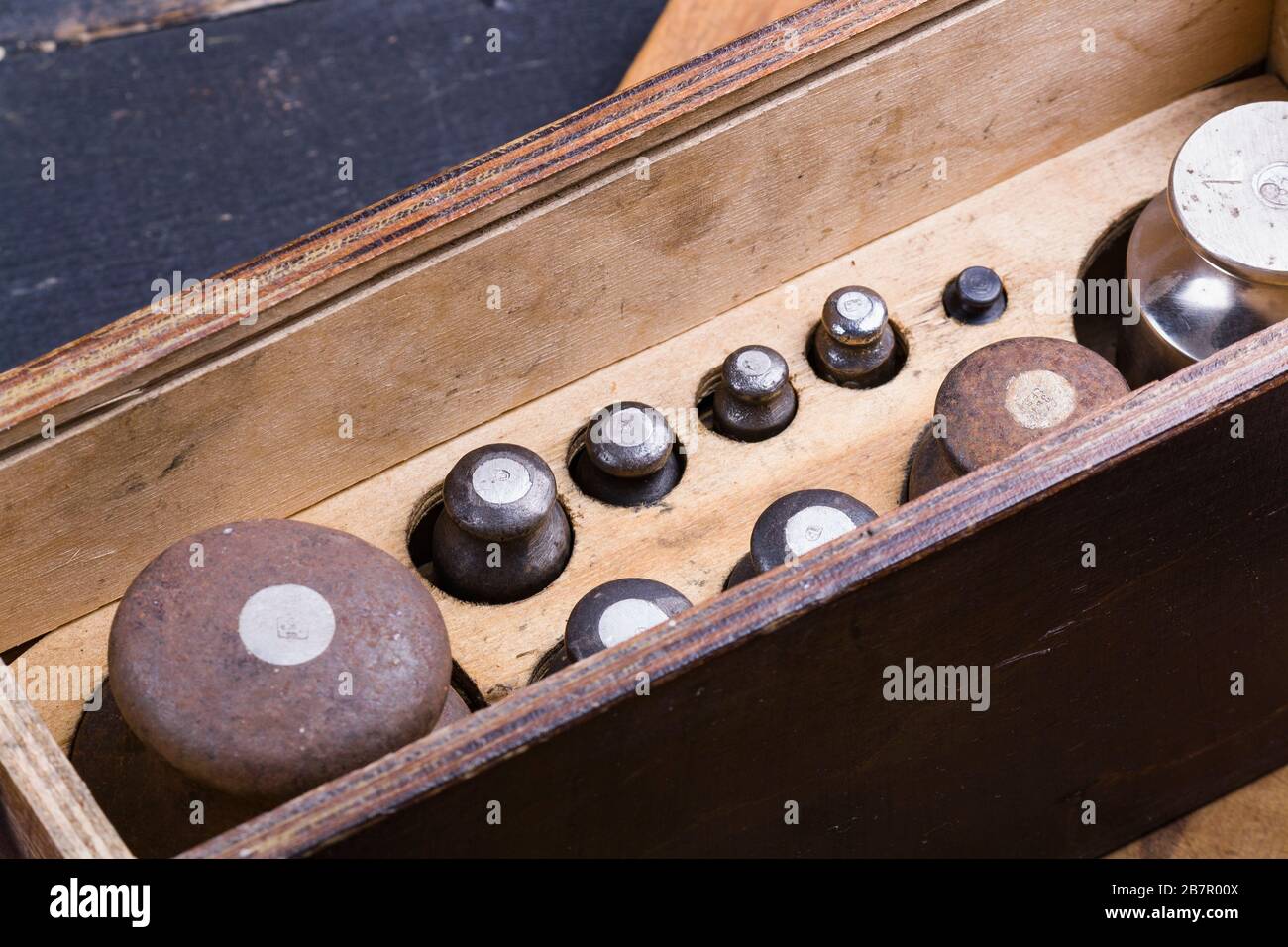 old vintage iron weights for weighing goods on a wooden background ...