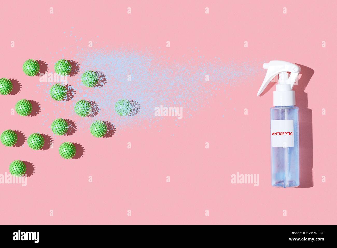 Antiseptic spray spraying against viruses on bright pink table flat lay ...
