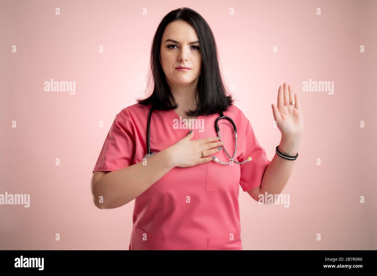 Portrait Of Beautiful Woman Doctor With Stethoscope Wearing Pink Scrubs