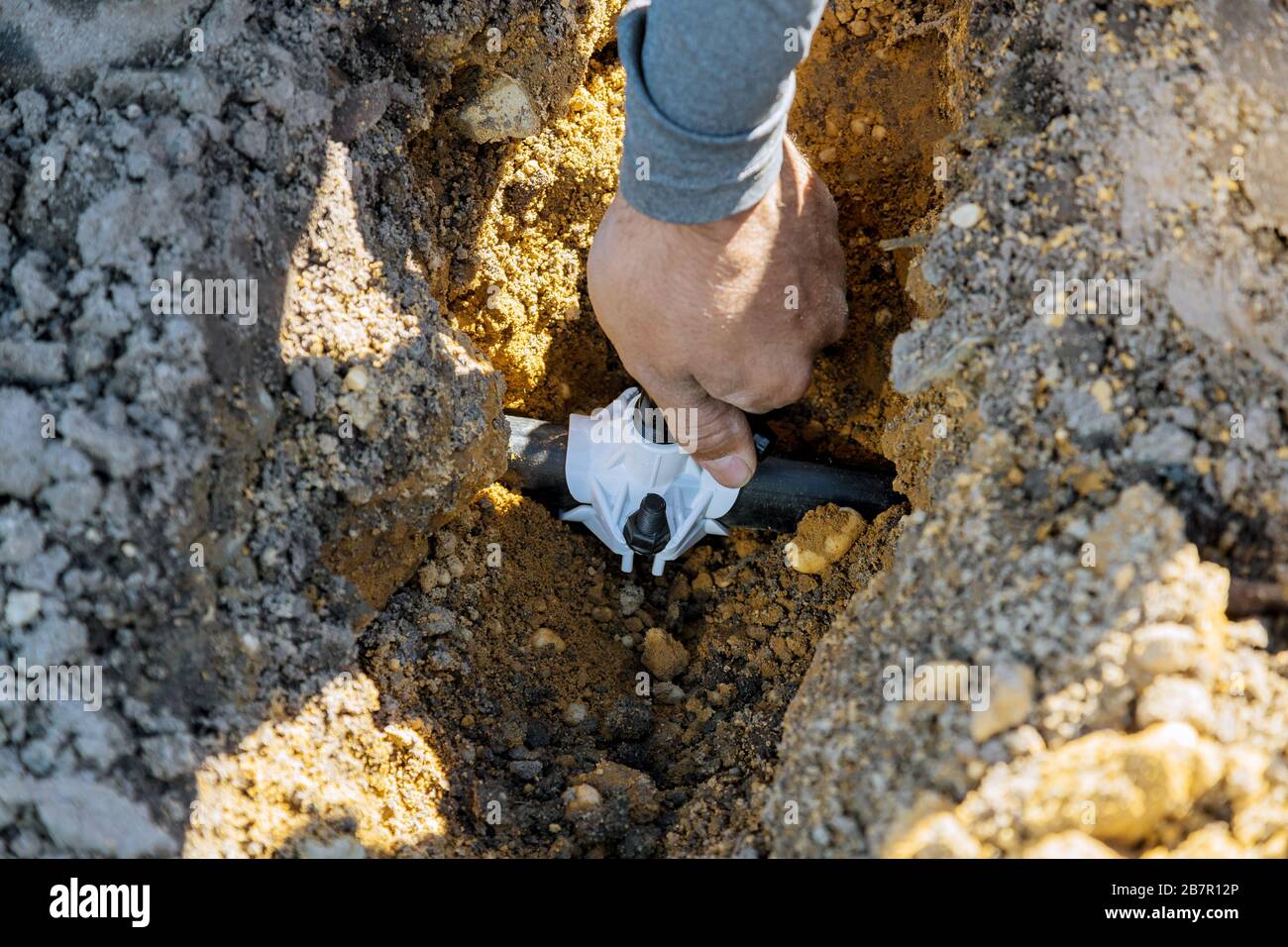 Garden workers installing in drip irrigation system of underground ...
