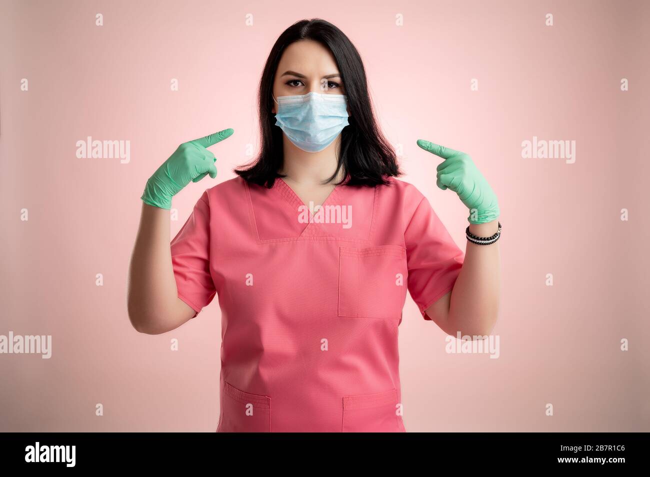 Portrait of beautiful woman doctor with stethoscope wearing pink scrubs ...
