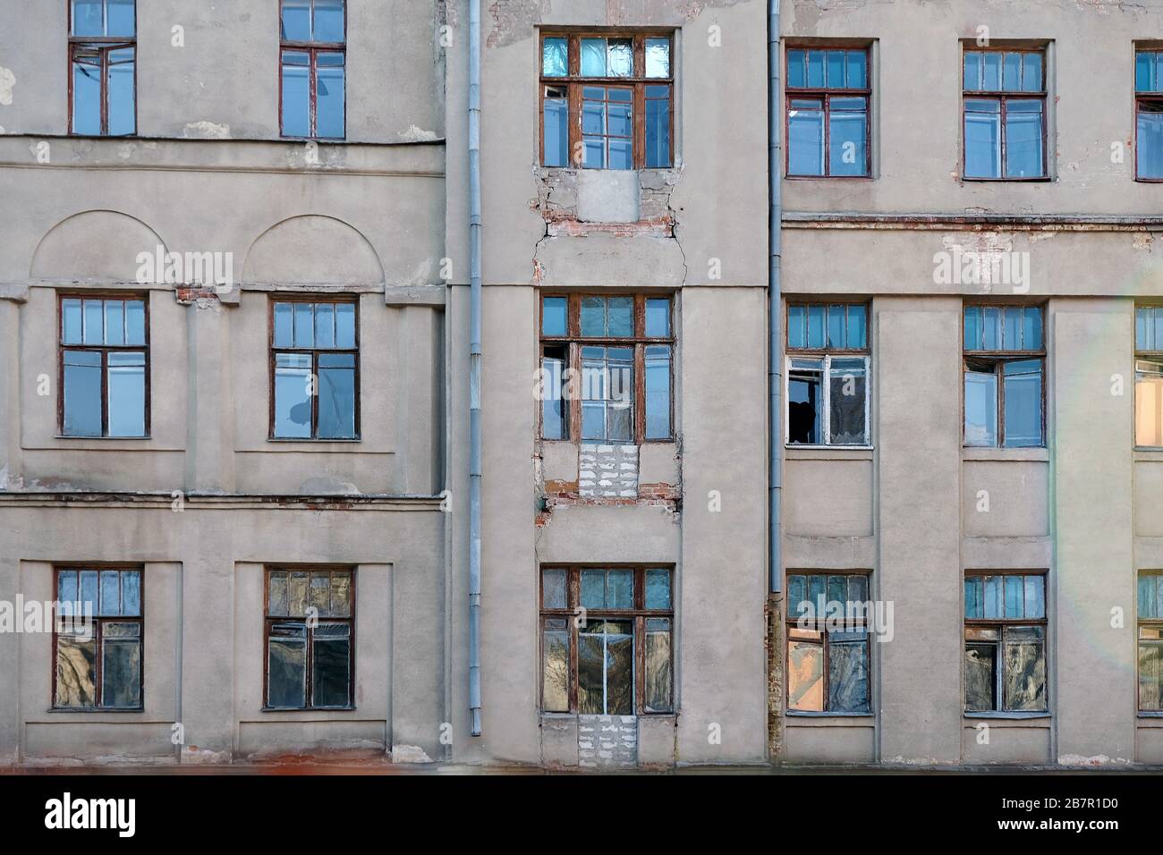 Old building facade with broken windows. Gray multi-storey building ...