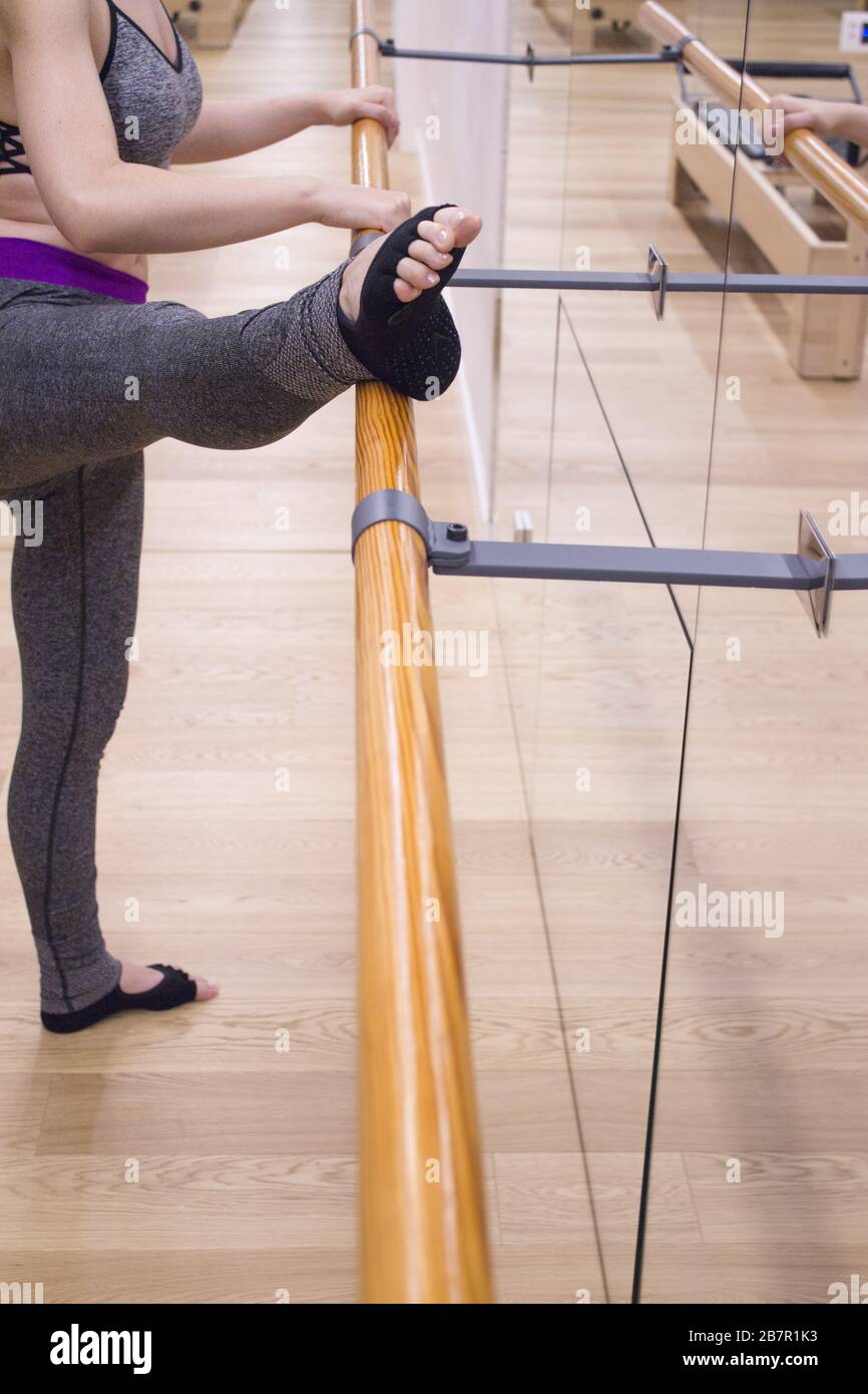 Female dancer doing leg stretches on the ballet barre Stock Photo - Alamy