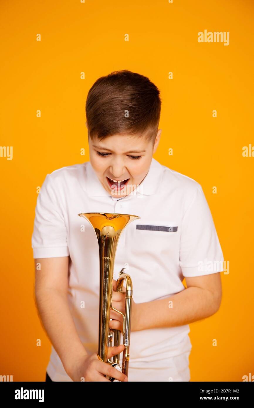 The boy screams into the pipe. Annoyed displeased boy shows his anger ...