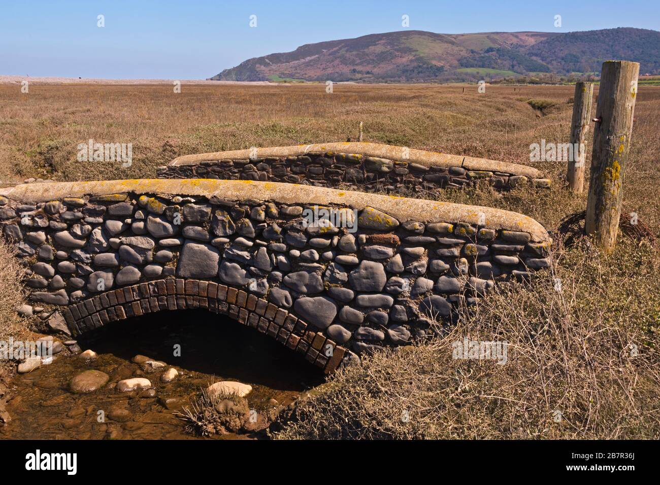 A stone footbridge over a creek in Porlock Marshes. near Porlock in the ...