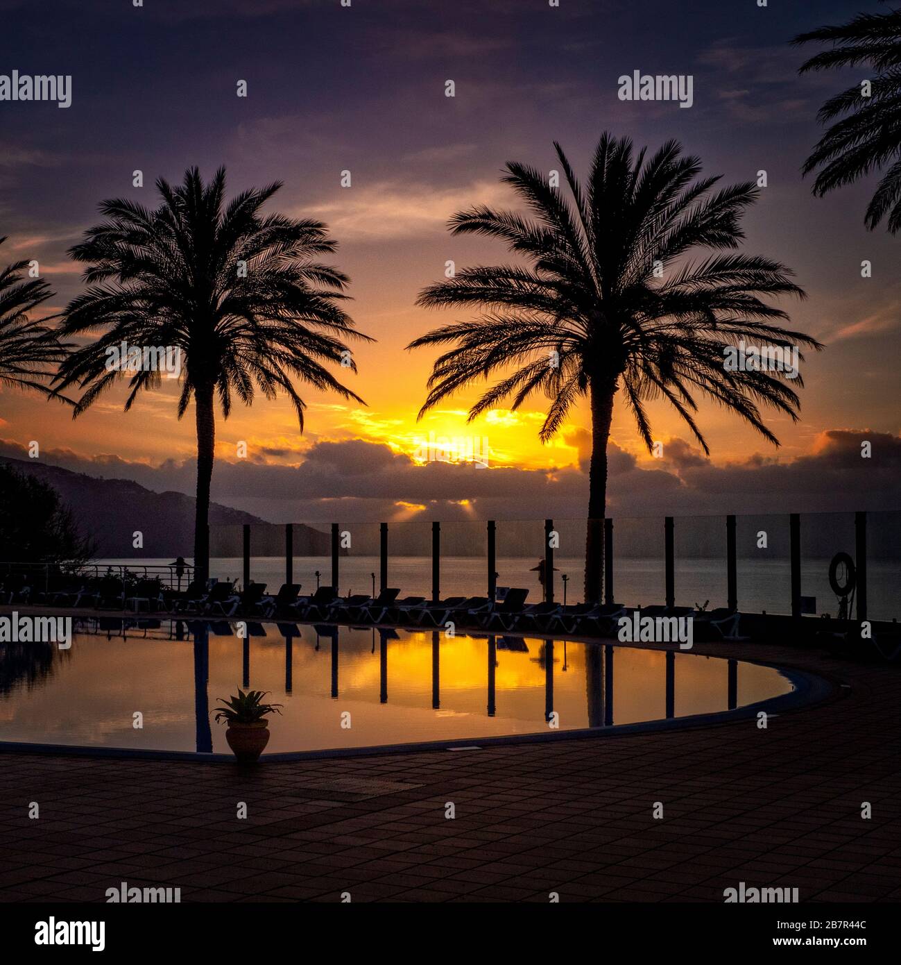 Sunset over swimming pool Stock Photo - Alamy