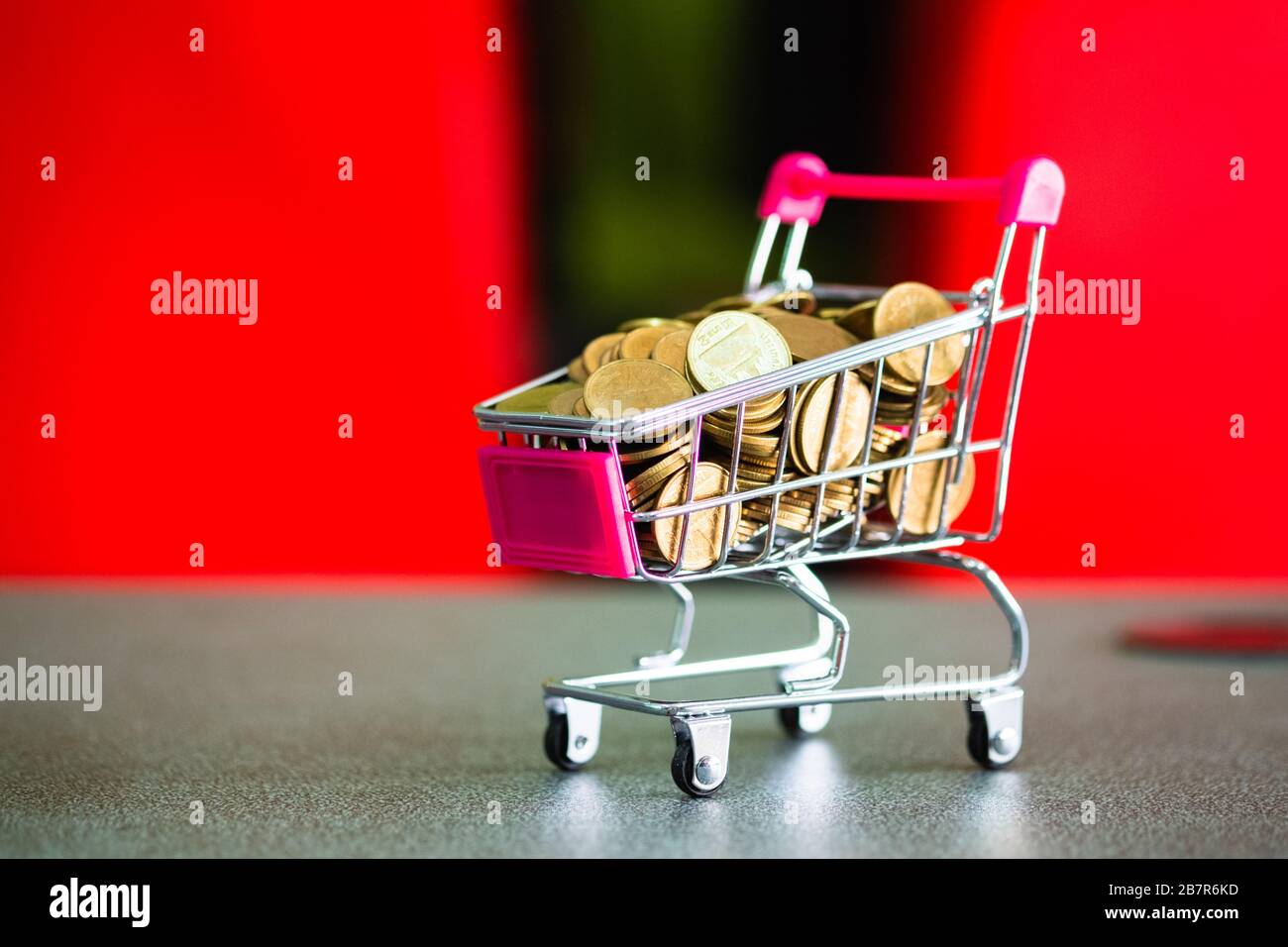 Coins in supermarket cart trolley on the table, business concept Stock ...
