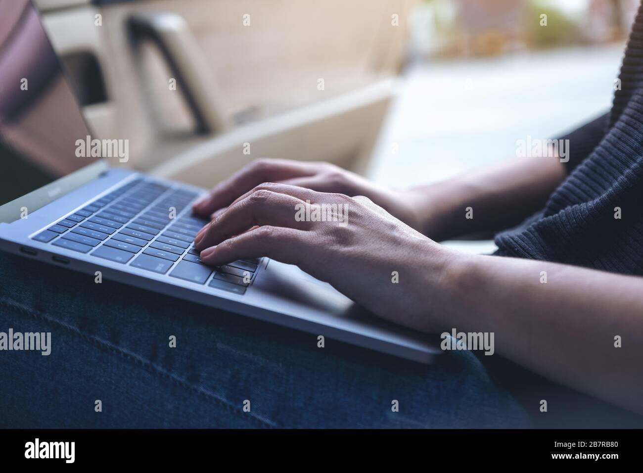 Closeup image of woman's hands working and typing on laptop keyboard on ...